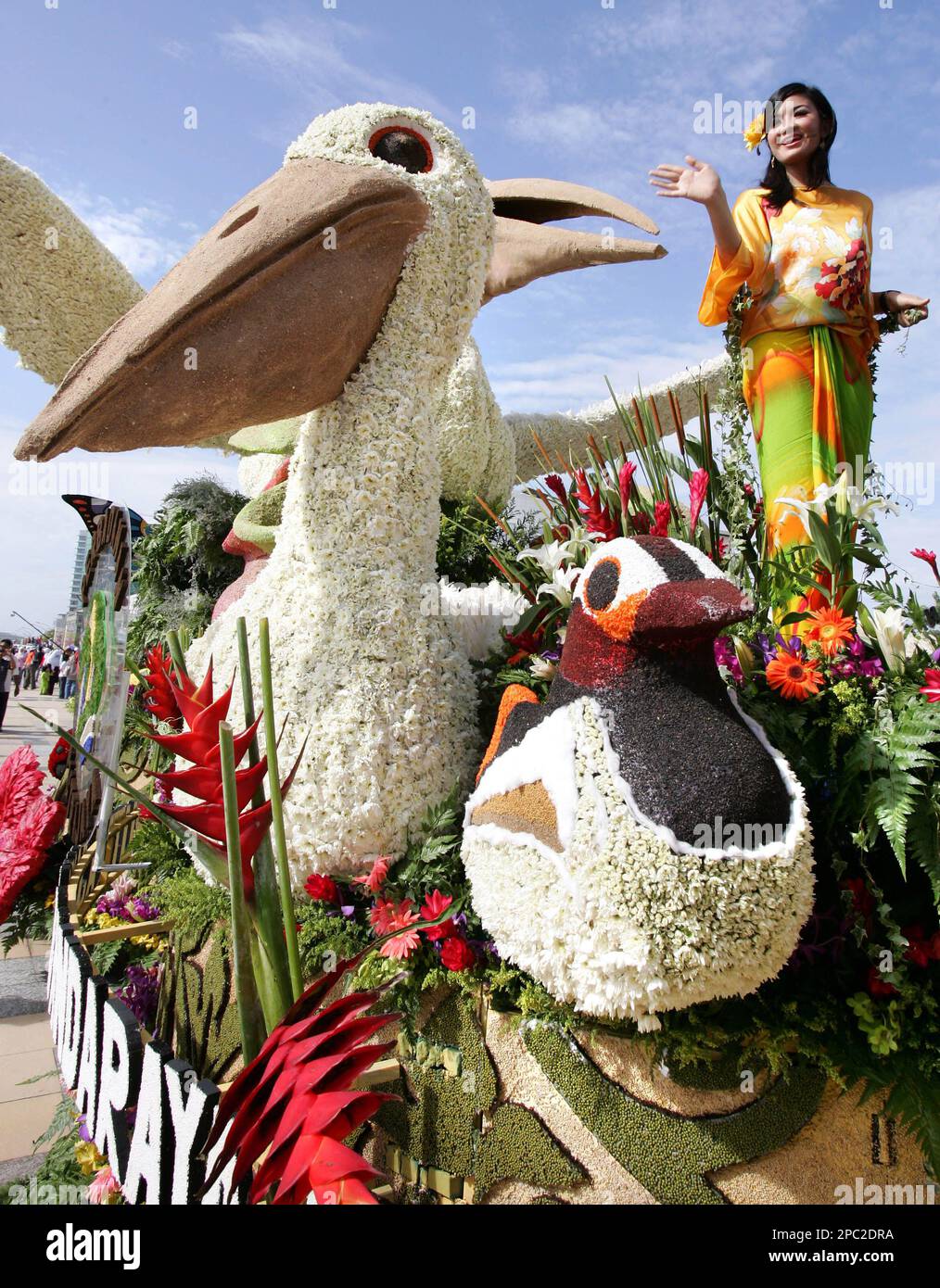 A participant waves to the crowds on the giant float made of flowers ...