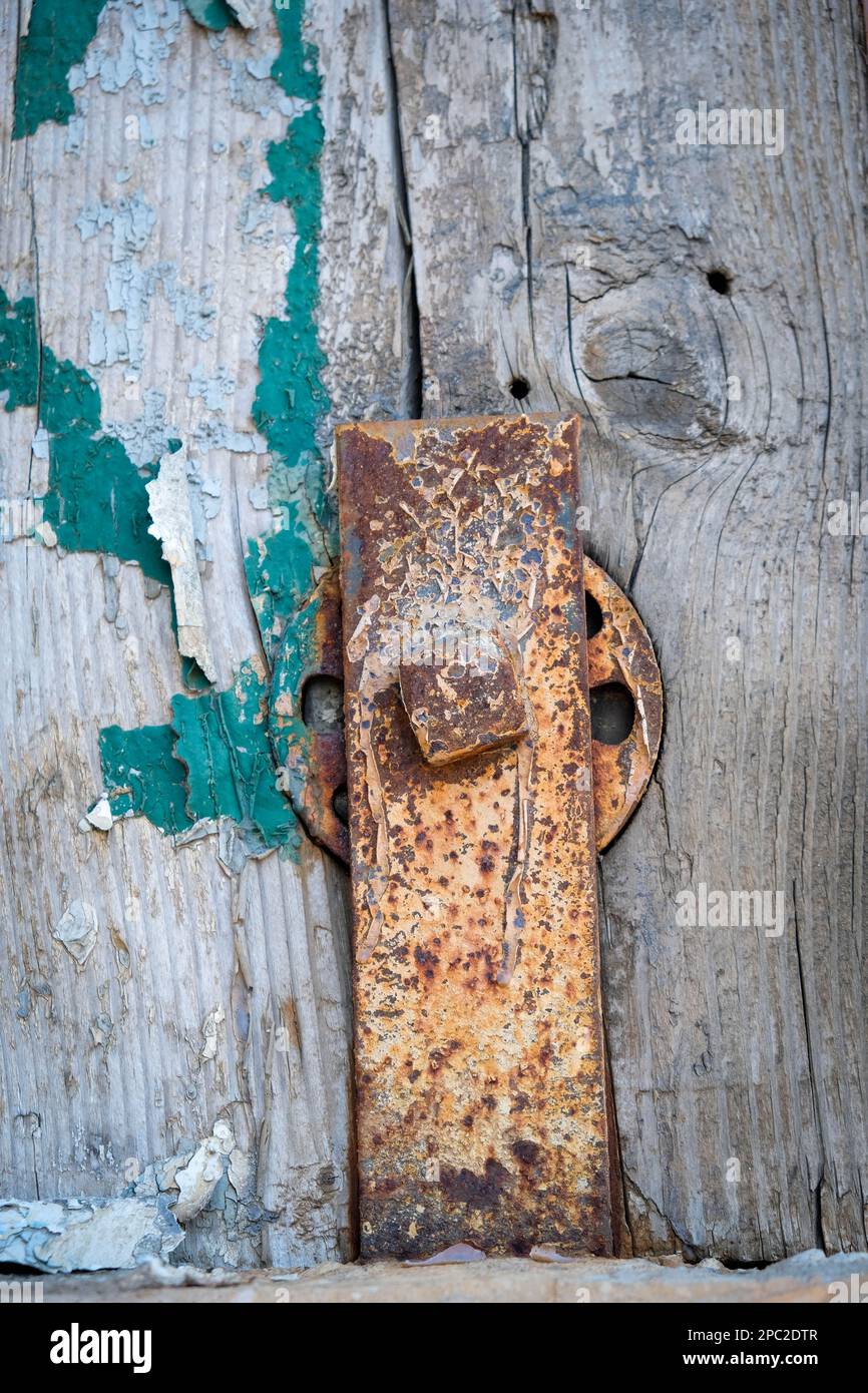 Rusted and painted old clasp with connector and boltt attached to wood ...