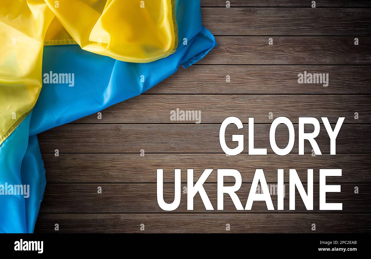 slogan Glory to Ukraine in Ukrainian on waved national flag Stock Photo ...