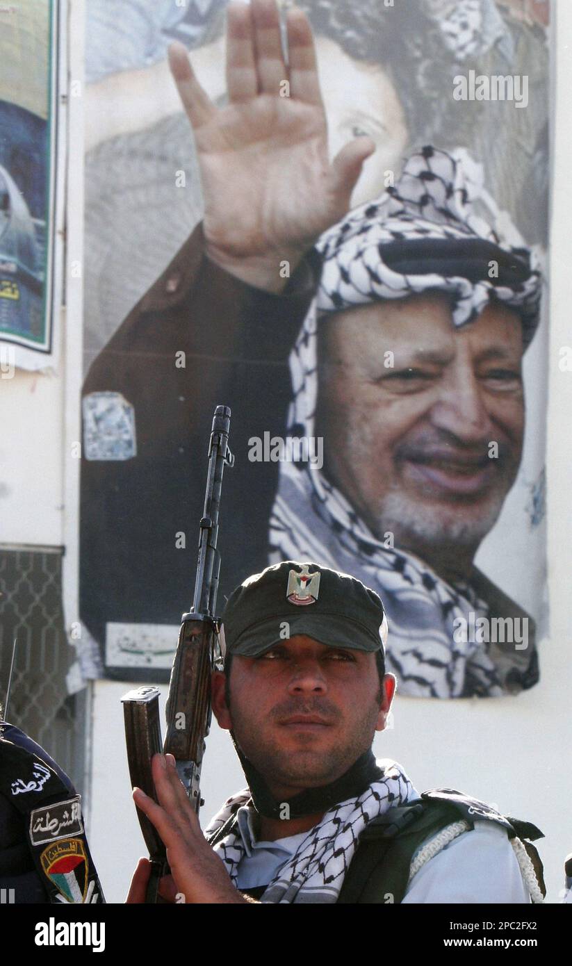 A Palestinian militant from the Fatah party holds his weapon next to a ...