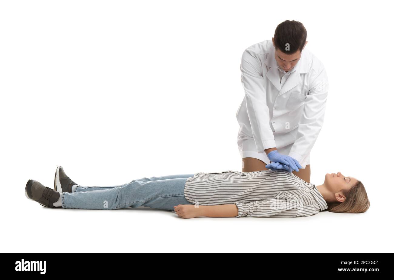 Doctor in uniform practicing first aid on woman against white ...