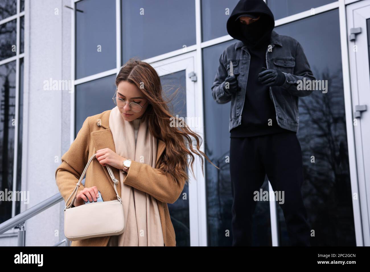 Man with knife stalking young woman near building Stock Photo - Alamy