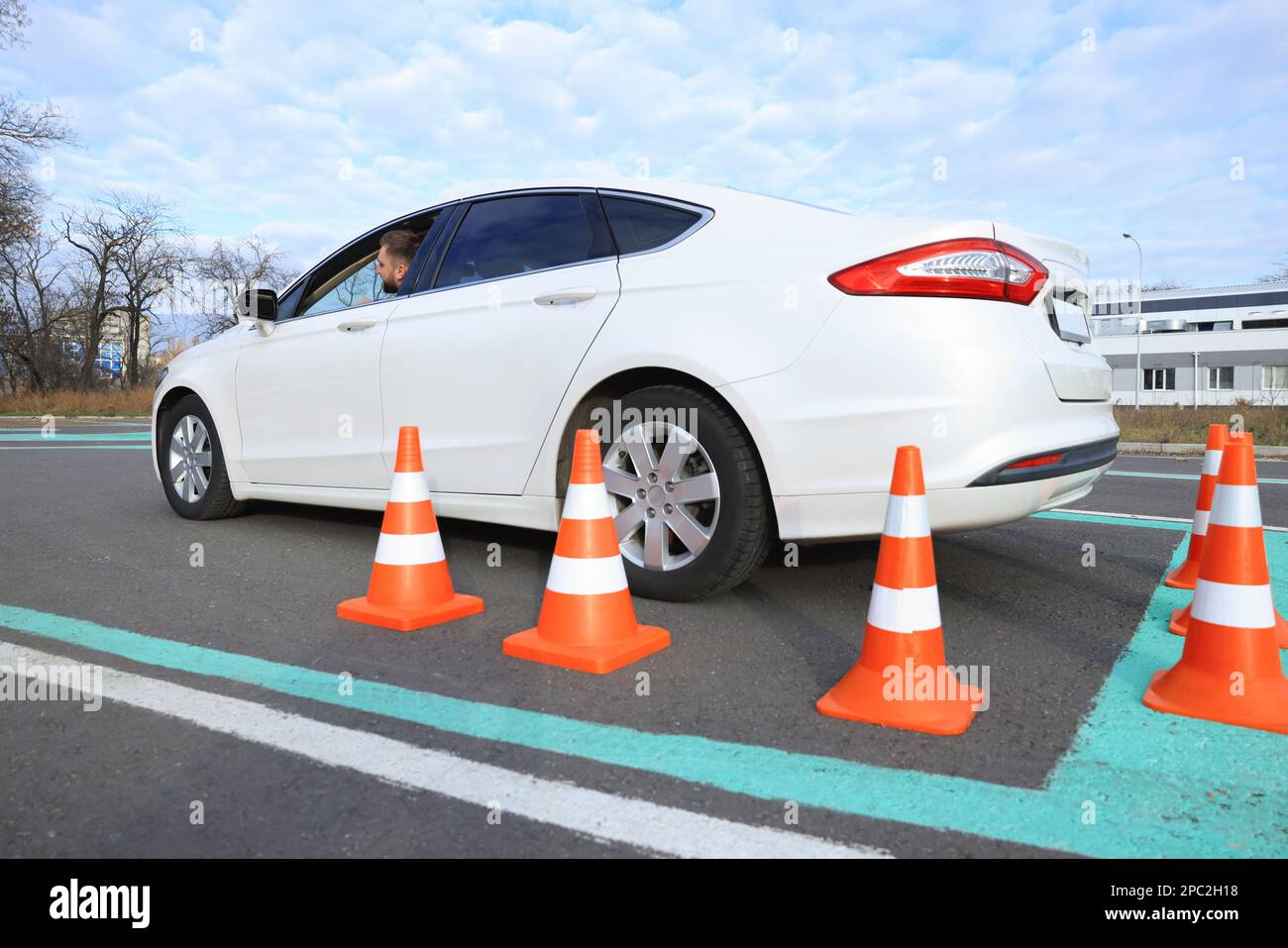 Young man in car on test track with traffic cones. Driving school Stock ...