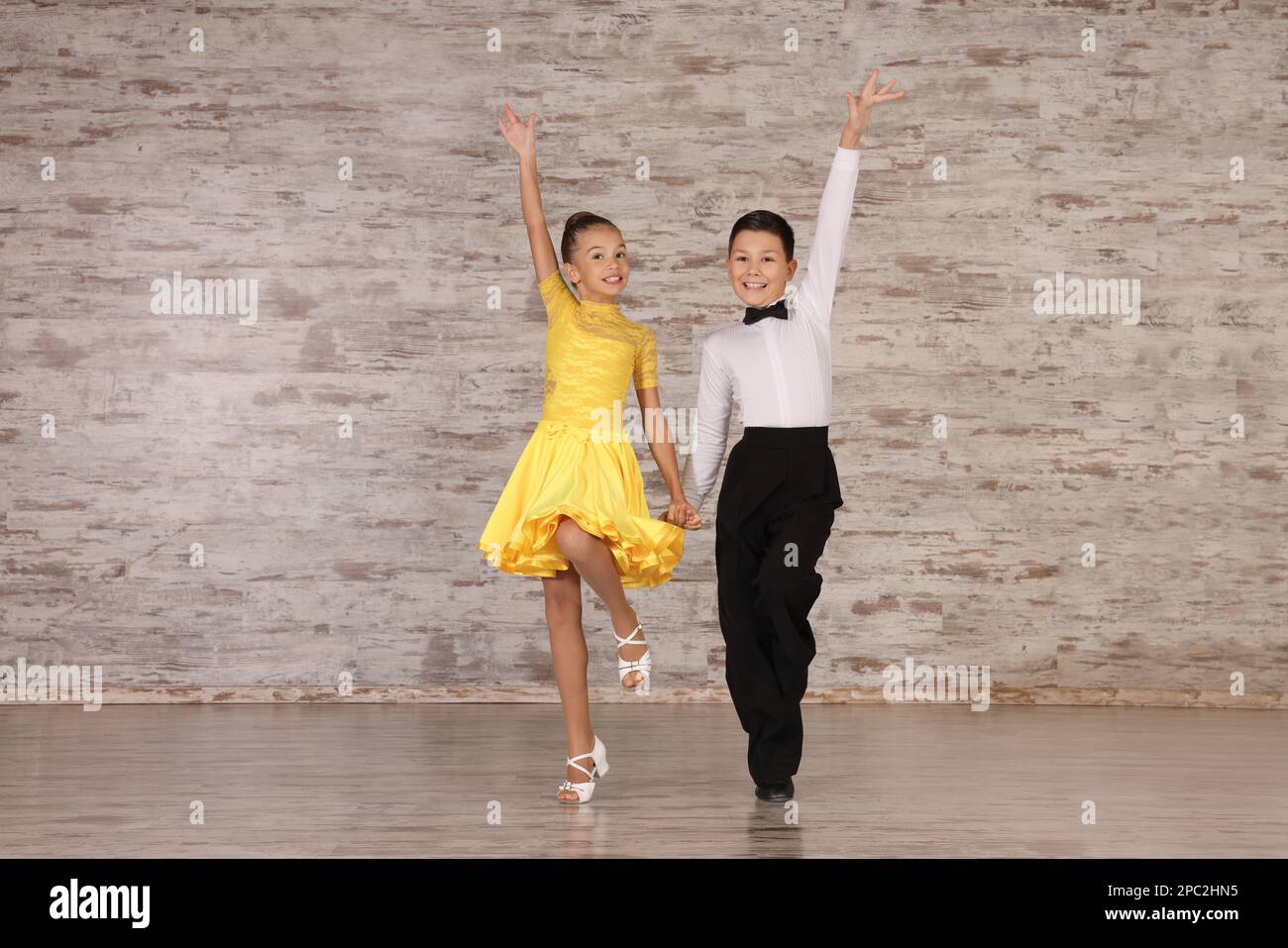 Beautifully dressed couple of kids dancing together in studio Stock ...