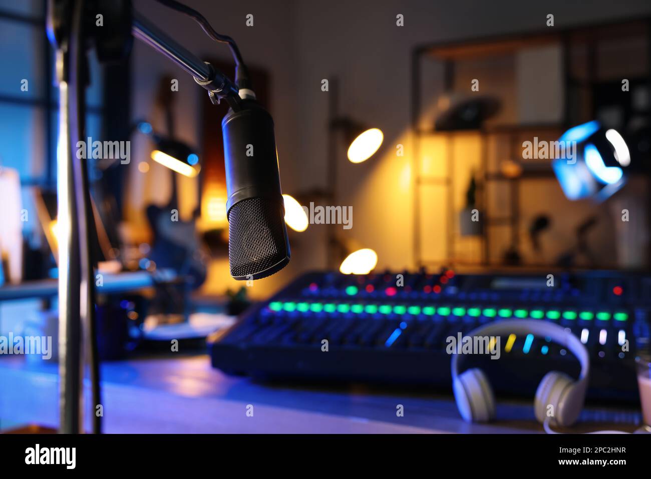 Microphone near table with professional mixing console in radio studio ...