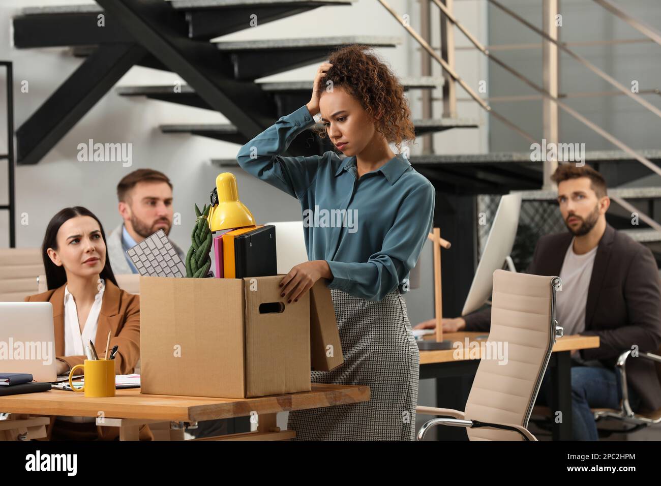 Young dismissed woman packing stuff into box at office Stock Photo - Alamy