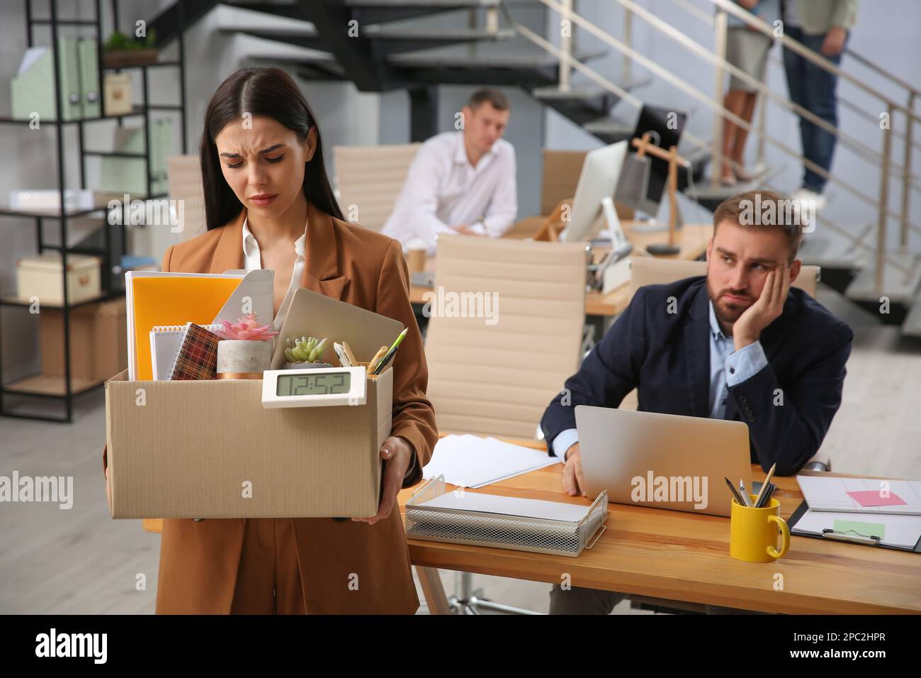Upset dismissed young woman carrying box with stuff in office Stock ...