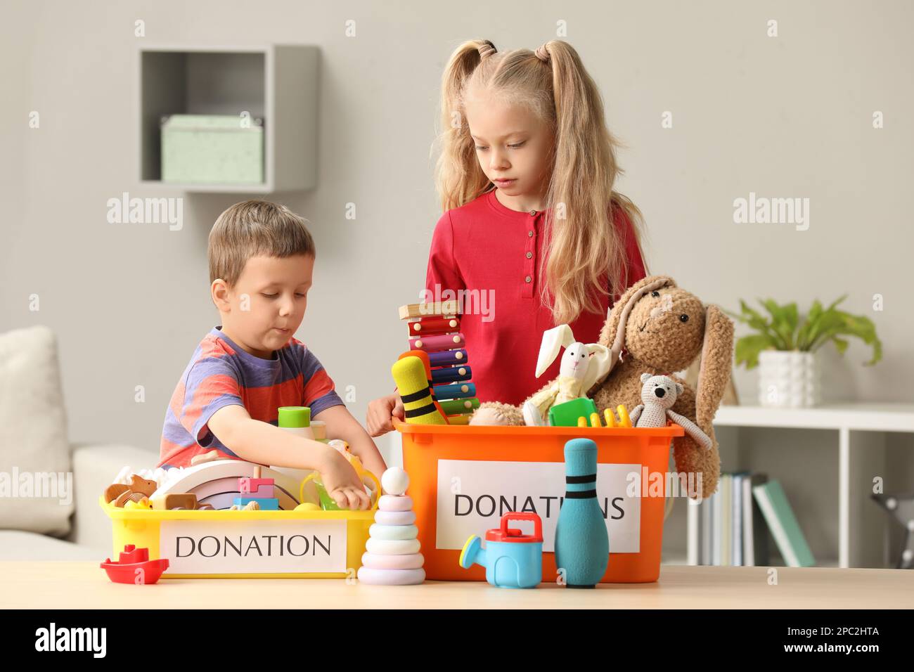 Cute little children sorting donation boxes at home Stock Photo - Alamy