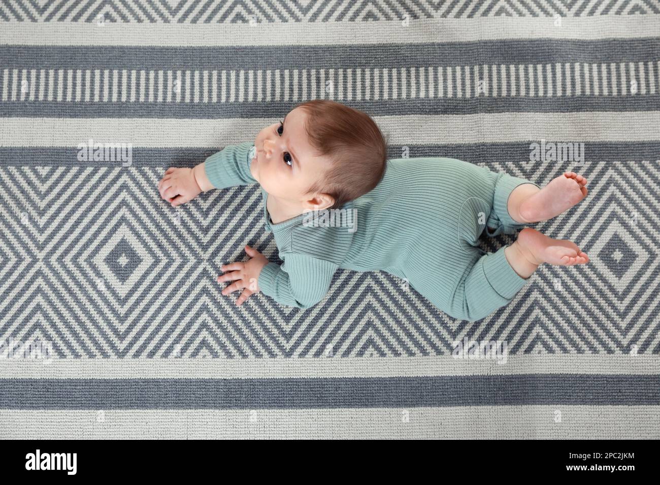 Cute baby crawling on floor, top view Stock Photo - Alamy