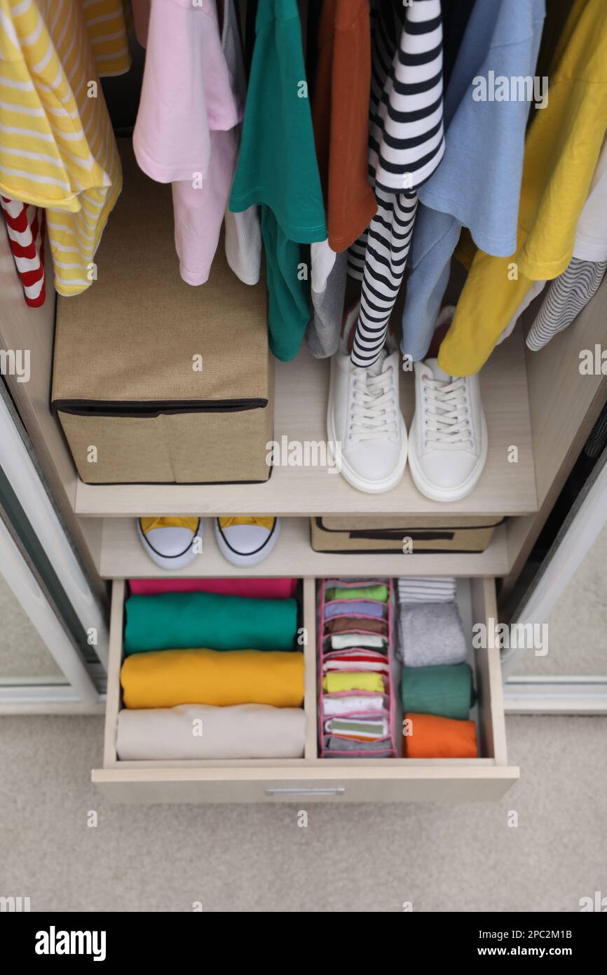 Wardrobe with organized clothes and shoes indoors, above view. Vertical ...