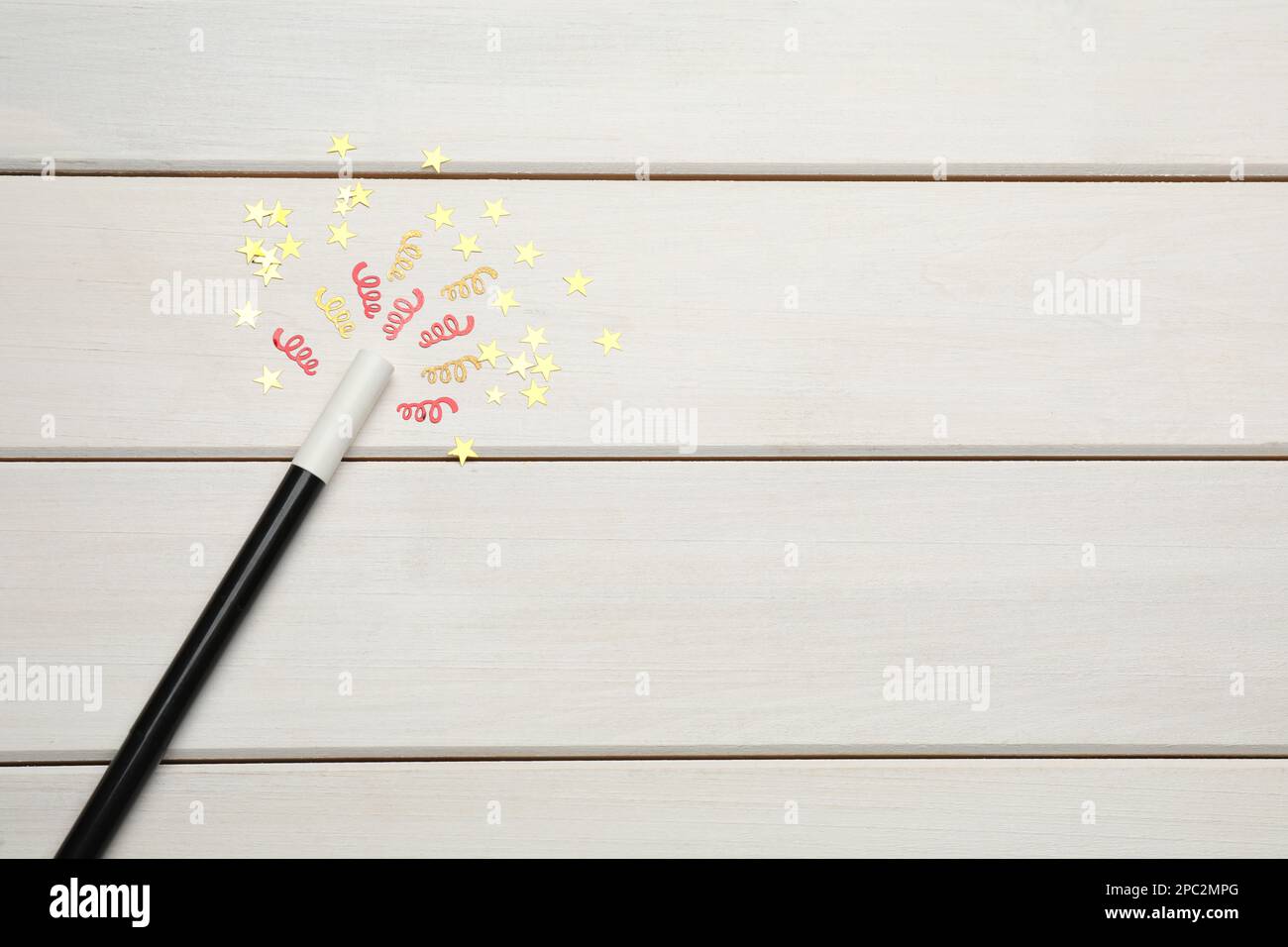 Beautiful black magic wand and confetti on white wooden table, flat lay ...