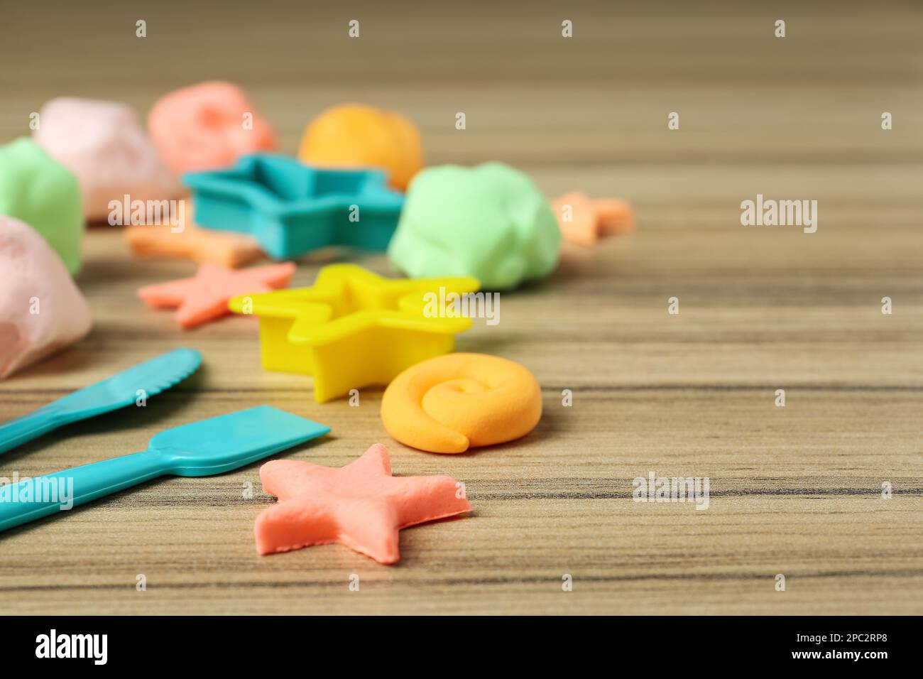 Different color play dough with tools and molds on wooden table ...