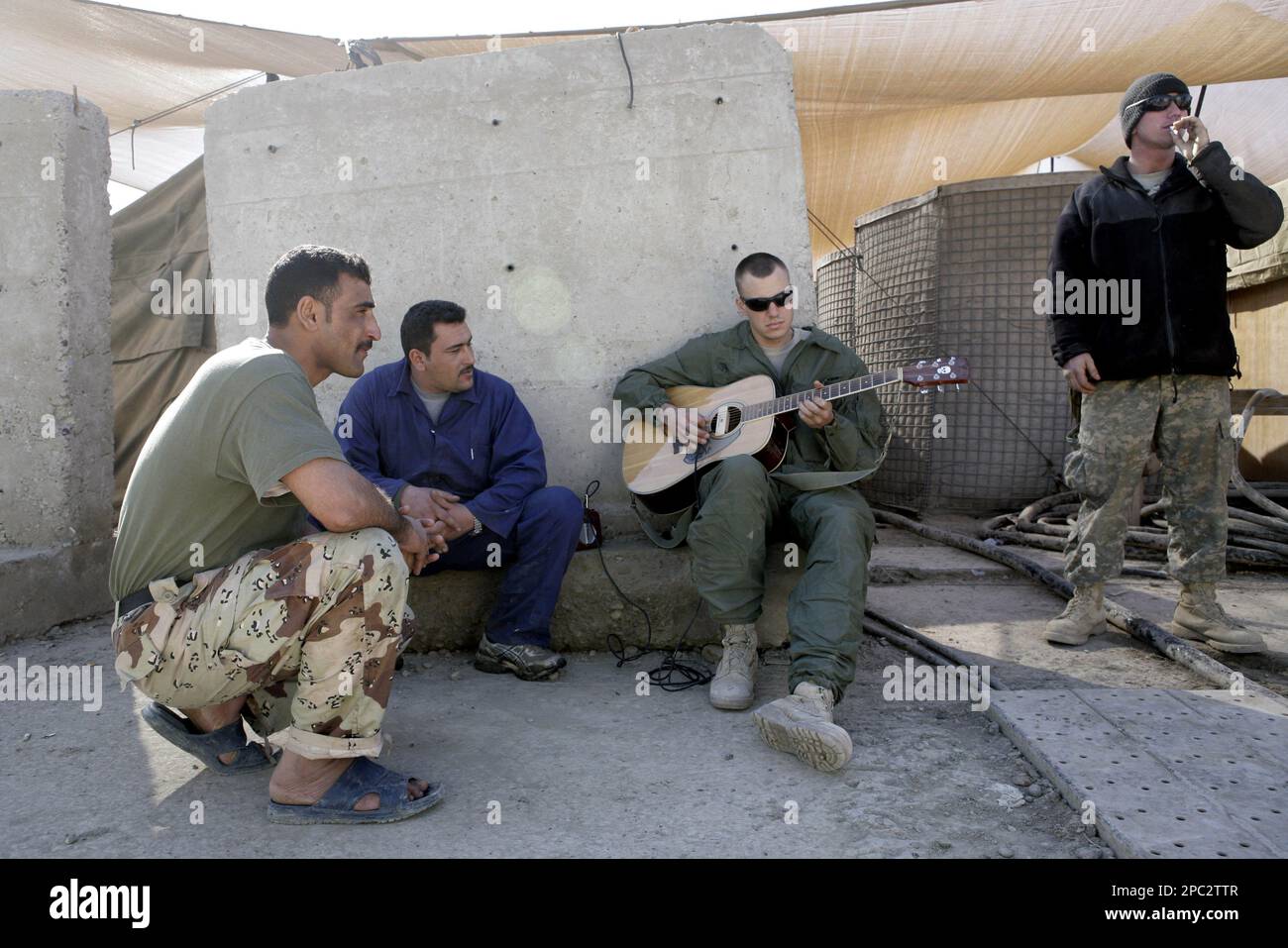 Army Spc. Brian Kohl, 26, from Pensacola, Fla., plays guitar for two ...