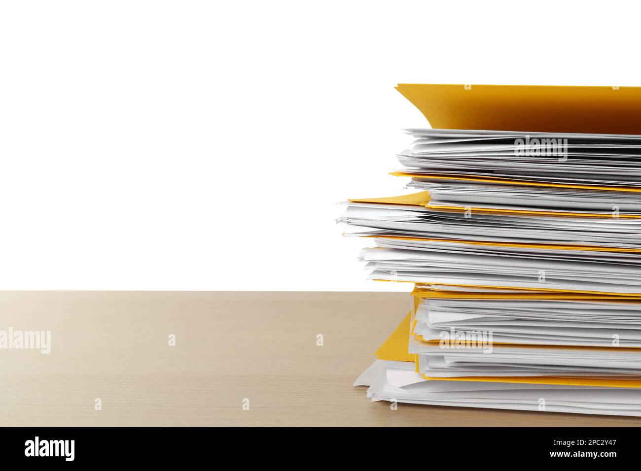 Stack of yellow files with documents on wooden table against white ...