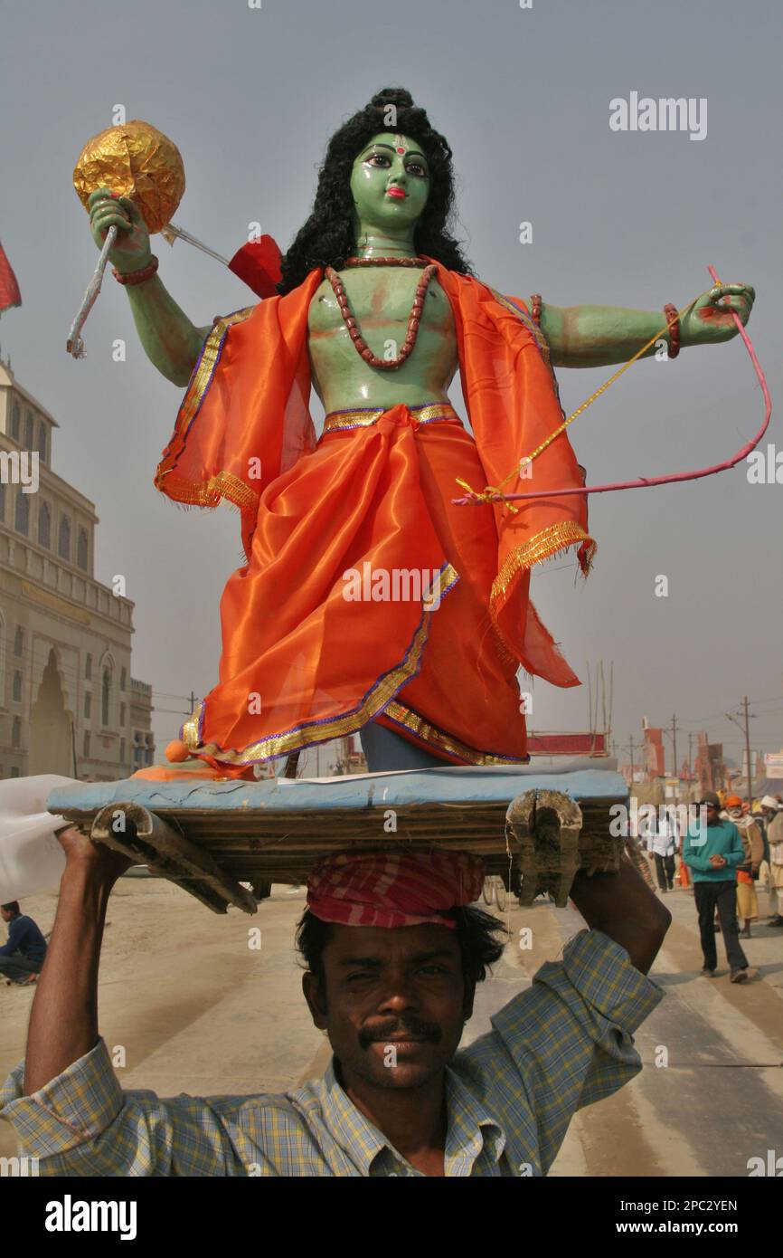 A devotee carries an idol of Hindu God Ram for immersion at Sangam, the ...