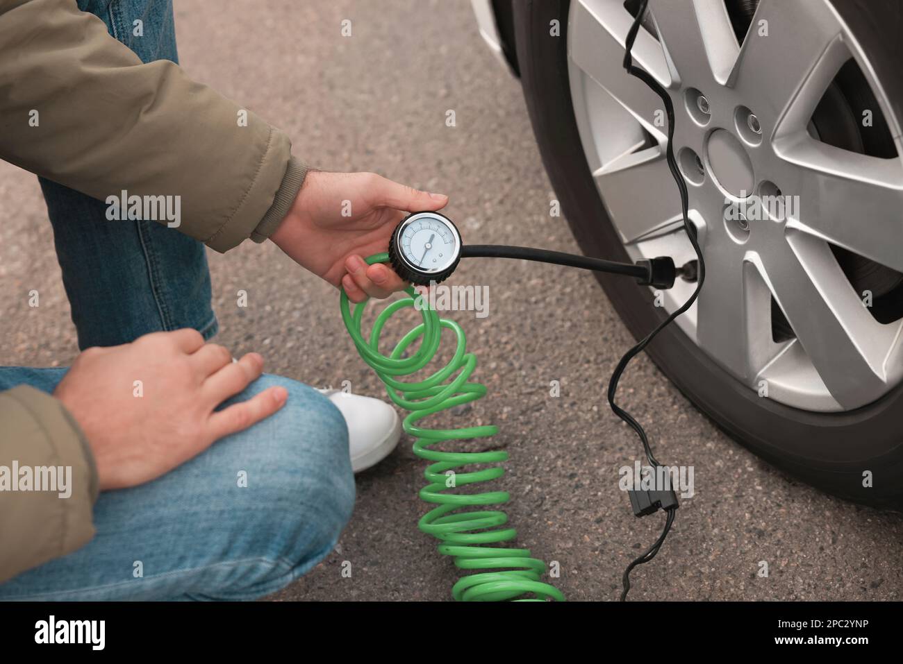 Man inflating car tire on street, closeup Stock Photo - Alamy