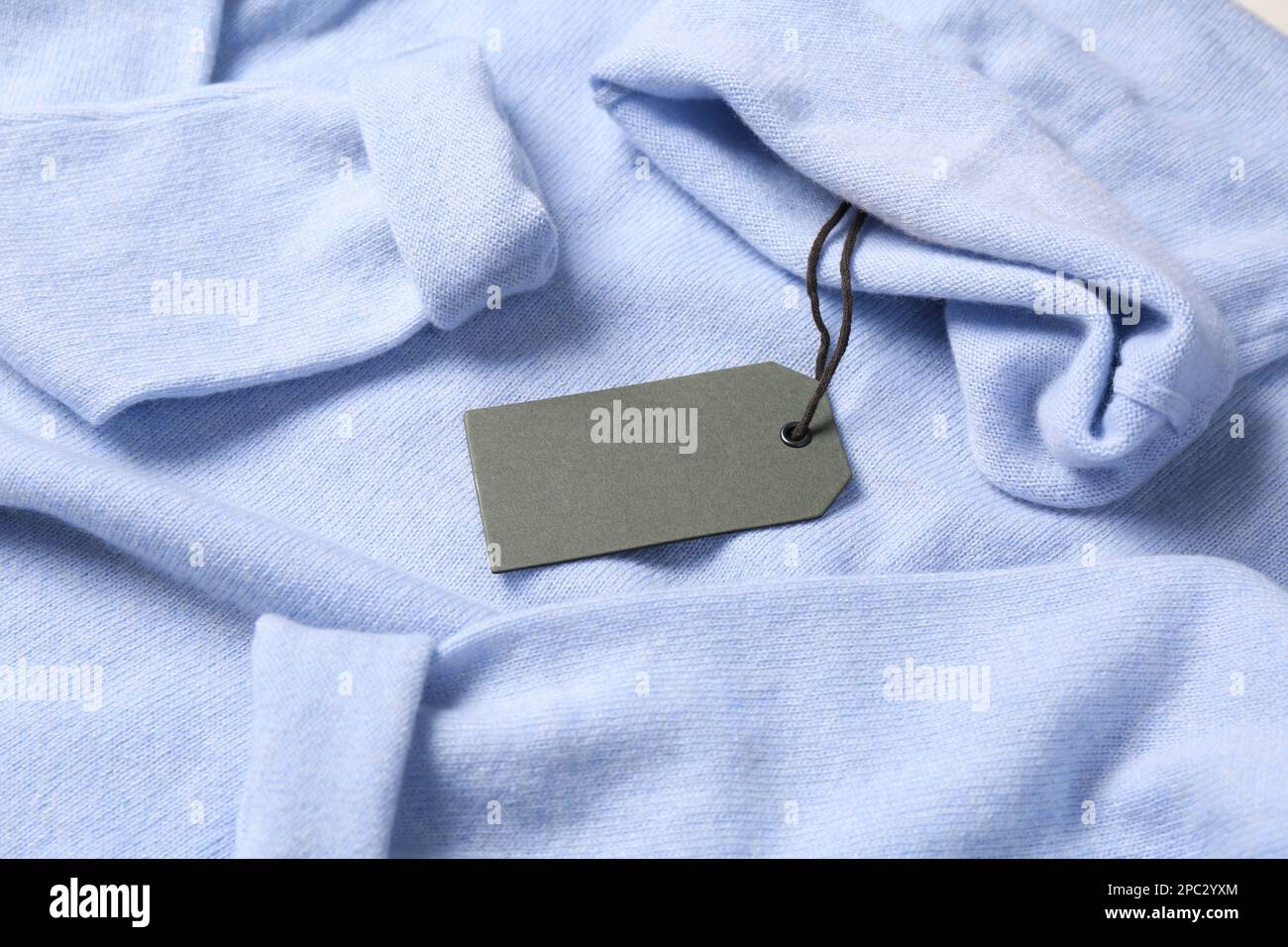 Blank grey tag on light blue sweater. Space for text Stock Photo - Alamy