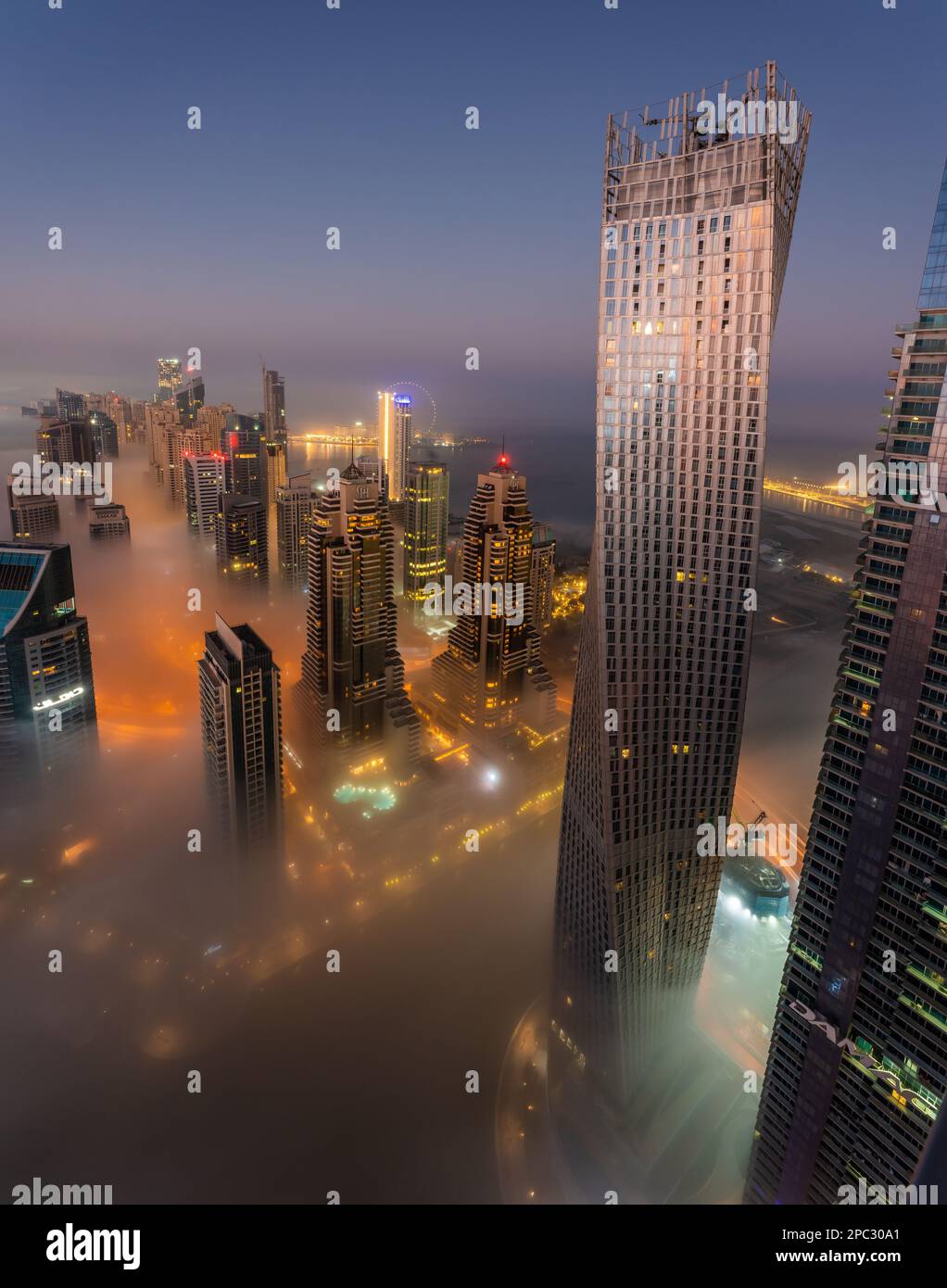 Sunrise shot of the Dubai Marina covered in a thick layer of fog with ...