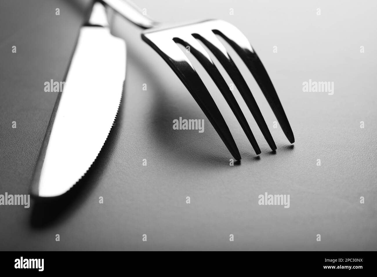 Shiny fork and knife on grey table, closeup Stock Photo - Alamy