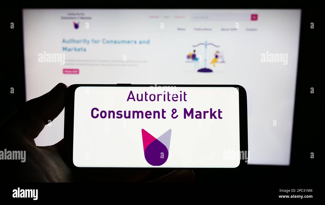 Person holding smartphone with logo of Dutch regulator Autoriteit ...