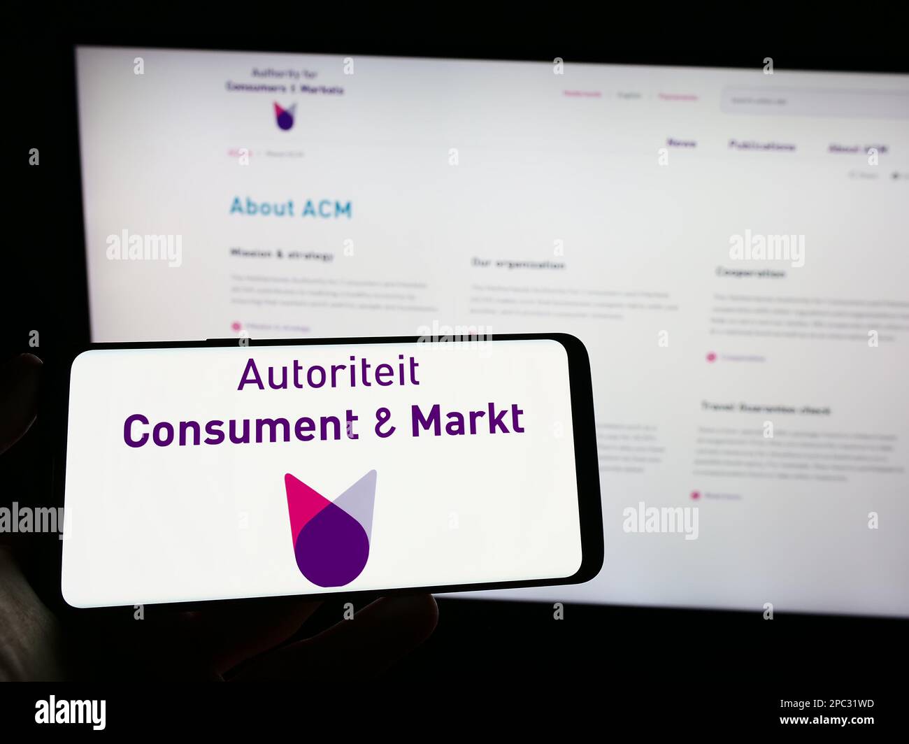 Person holding mobile phone with logo of Dutch regulator Autoriteit ...