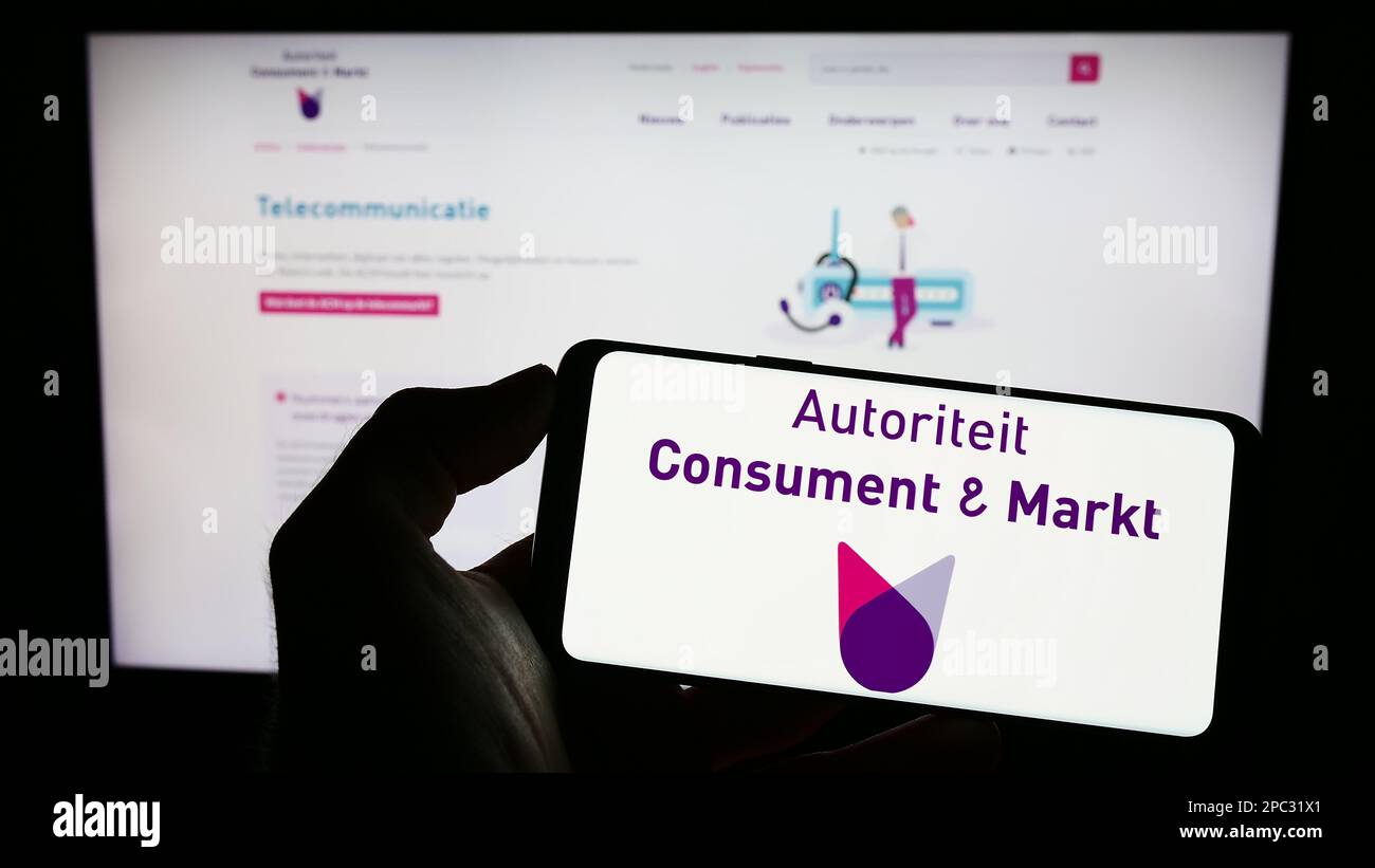 Person holding cellphone with logo of Dutch regulator Autoriteit ...