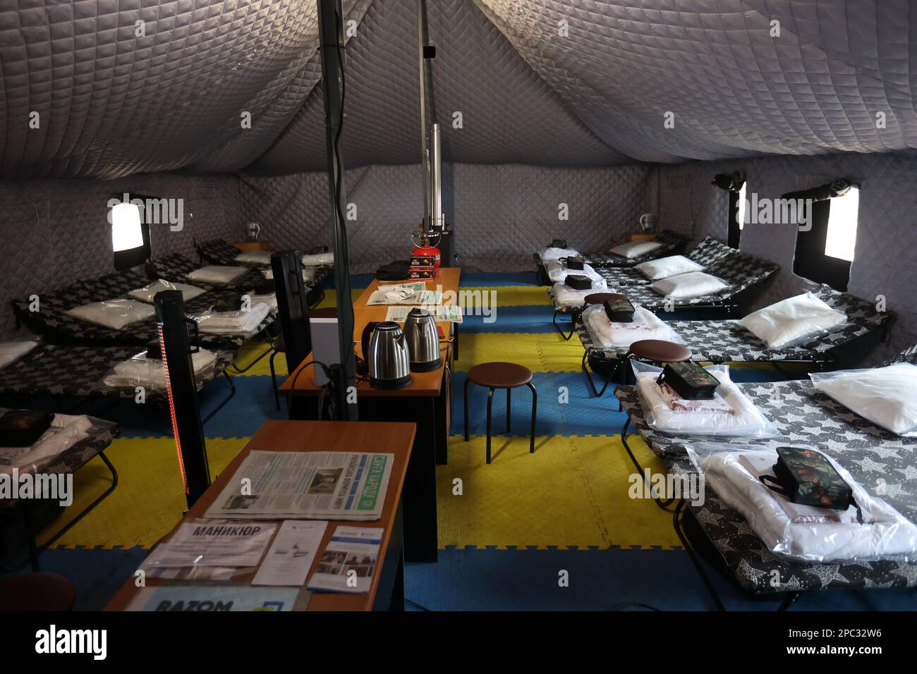 TSYRKUNY, UKRAINE - MARCH 11, 2023 - Camp beds flank the tables in a ...