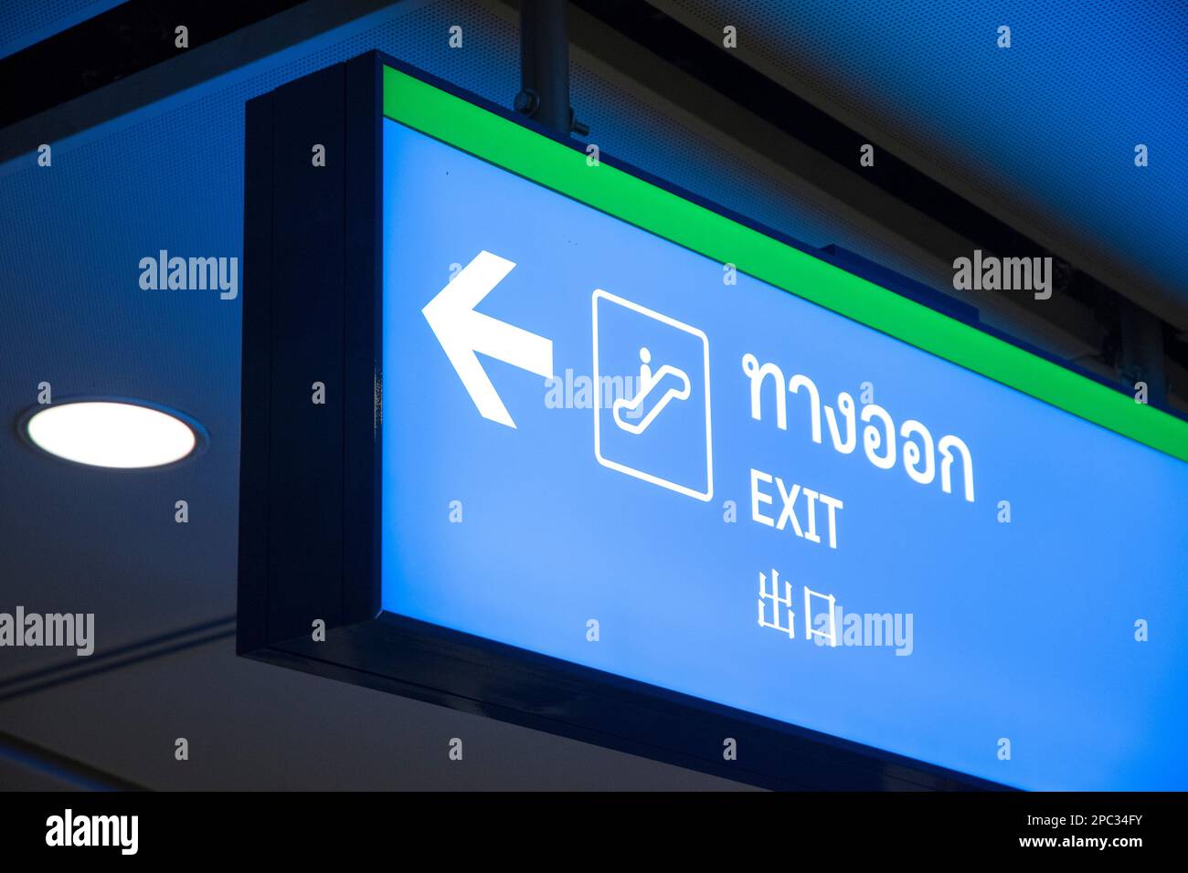 Exit sign with Chinese, Thai and English languages with blue banner ...