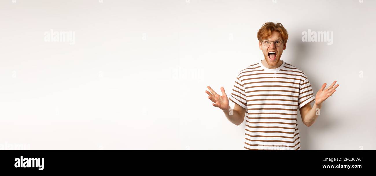 Frustrated man with red hair shaking hands and yelling at camera ...