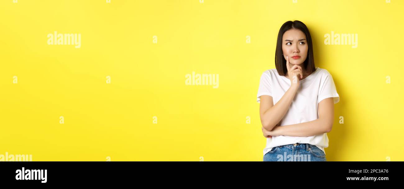Beauty and fashion concept. Pensive asian woman thinking, looking ...