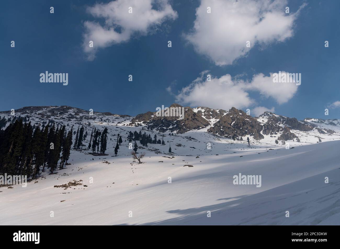 A mountain is seen partially covered with snow during a sunny day at ...