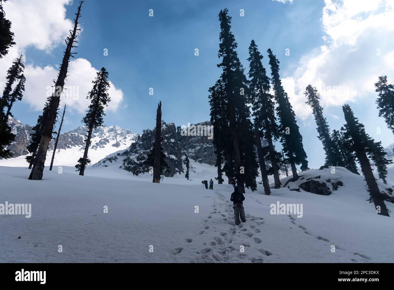 Trekkers are seen enroute their way through a snow covered mountain ...