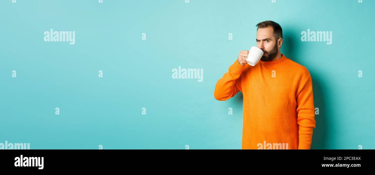 Image of guy drinking coffee and looking suspicious at camera, stare at ...