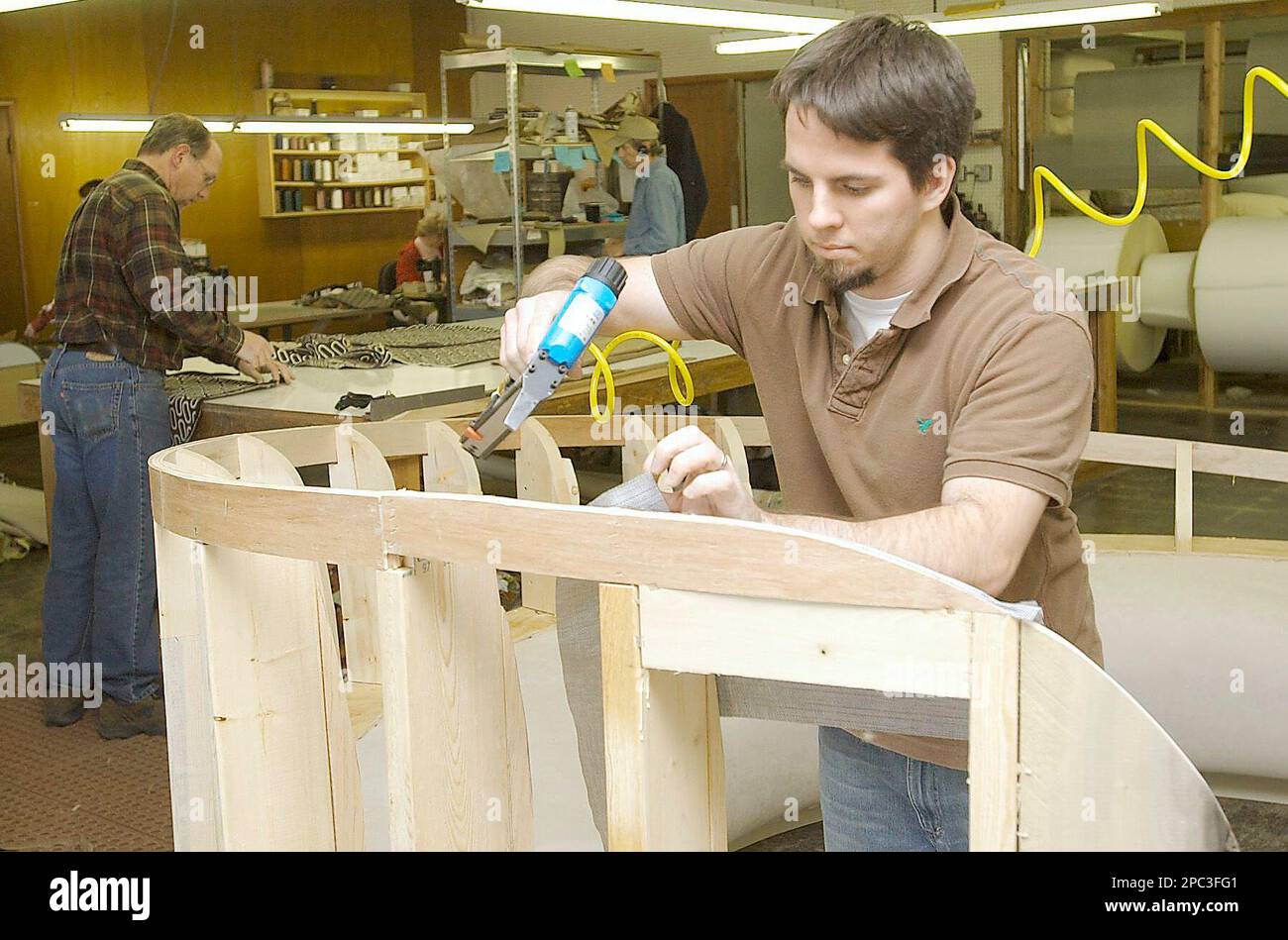 Greg Thayer of Thayer Upholstery works on a custom banquette in January ...