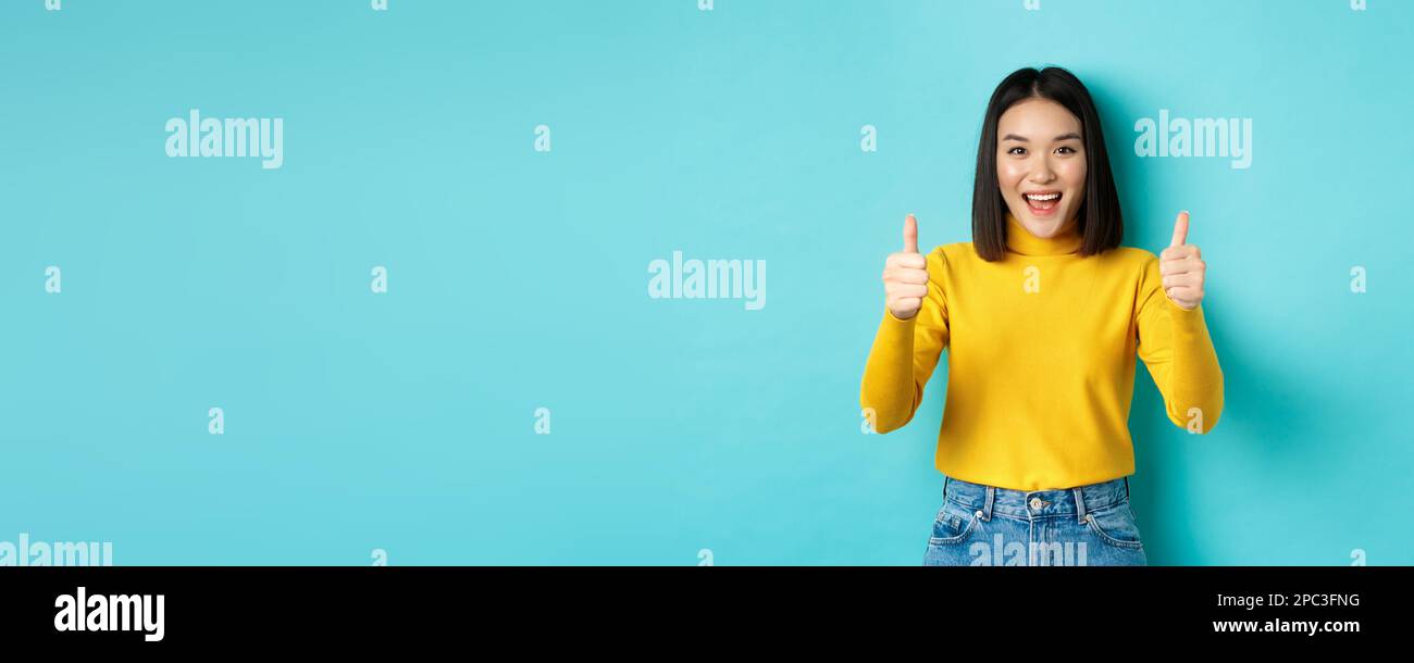 Beautiful asian woman praise good work, showing thumbs up gesture and ...