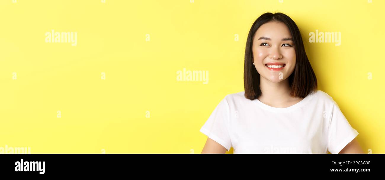 Close up of good-looking asian woman in white t-shirt, smiling and ...