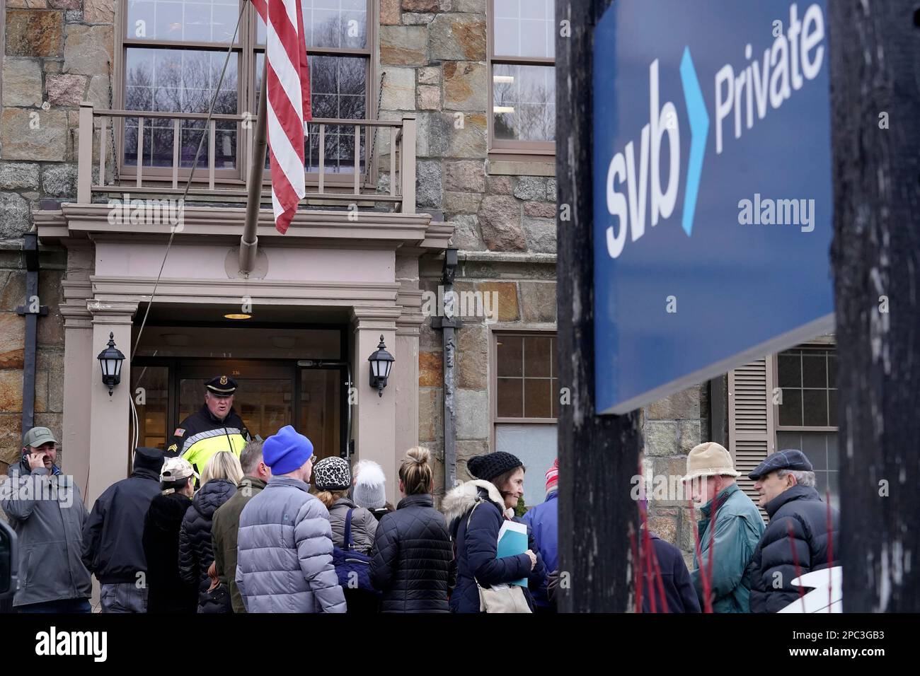 A law enforcement official, behind, stands in an entryway to a branch ...