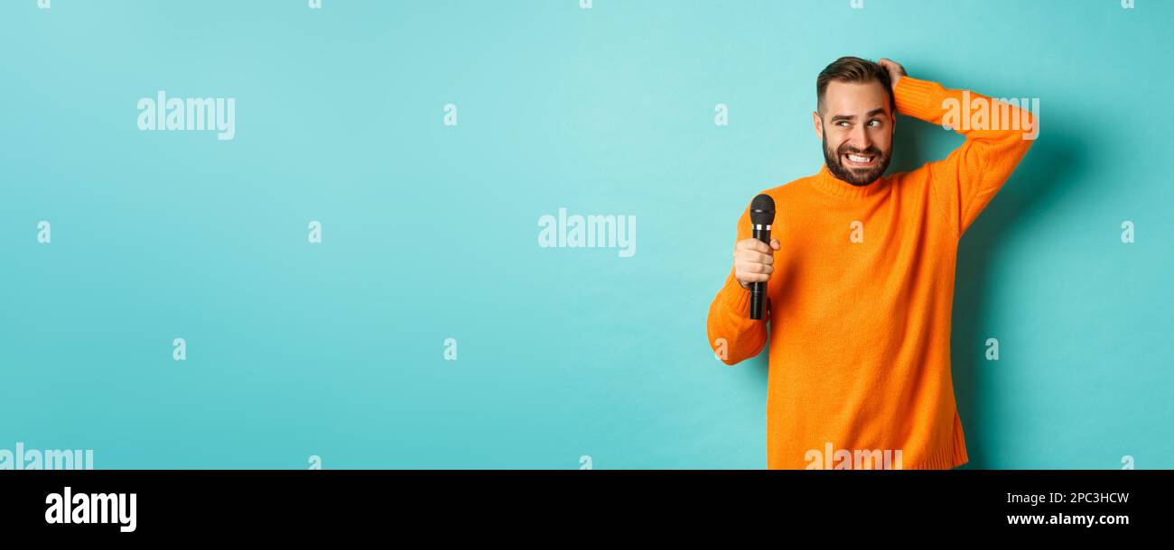 Shy And Awkward Adult Man Scratching Head Holding Microphone Before