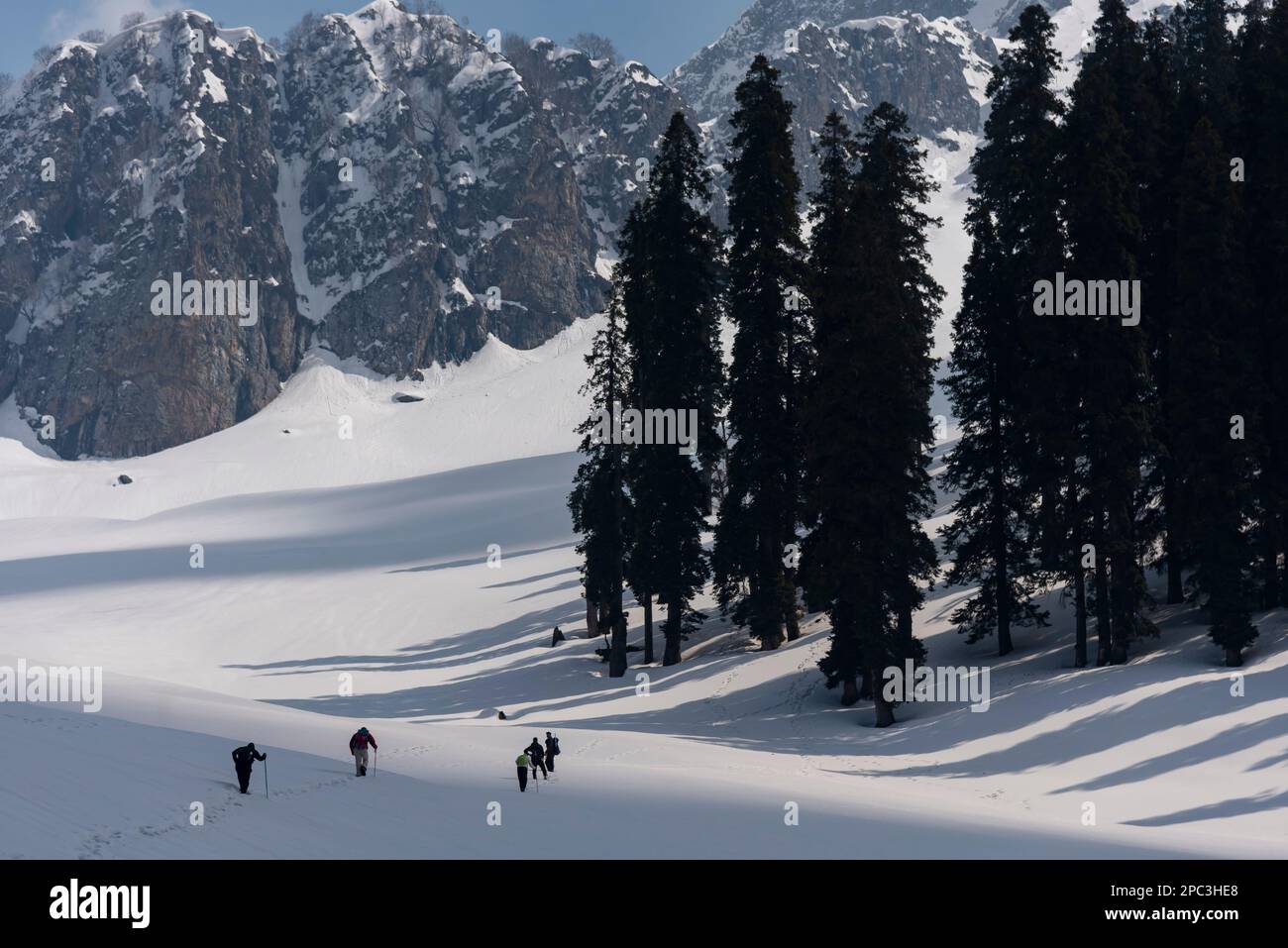 Trekkers are seen enroute their way through a snow covered mountain ...