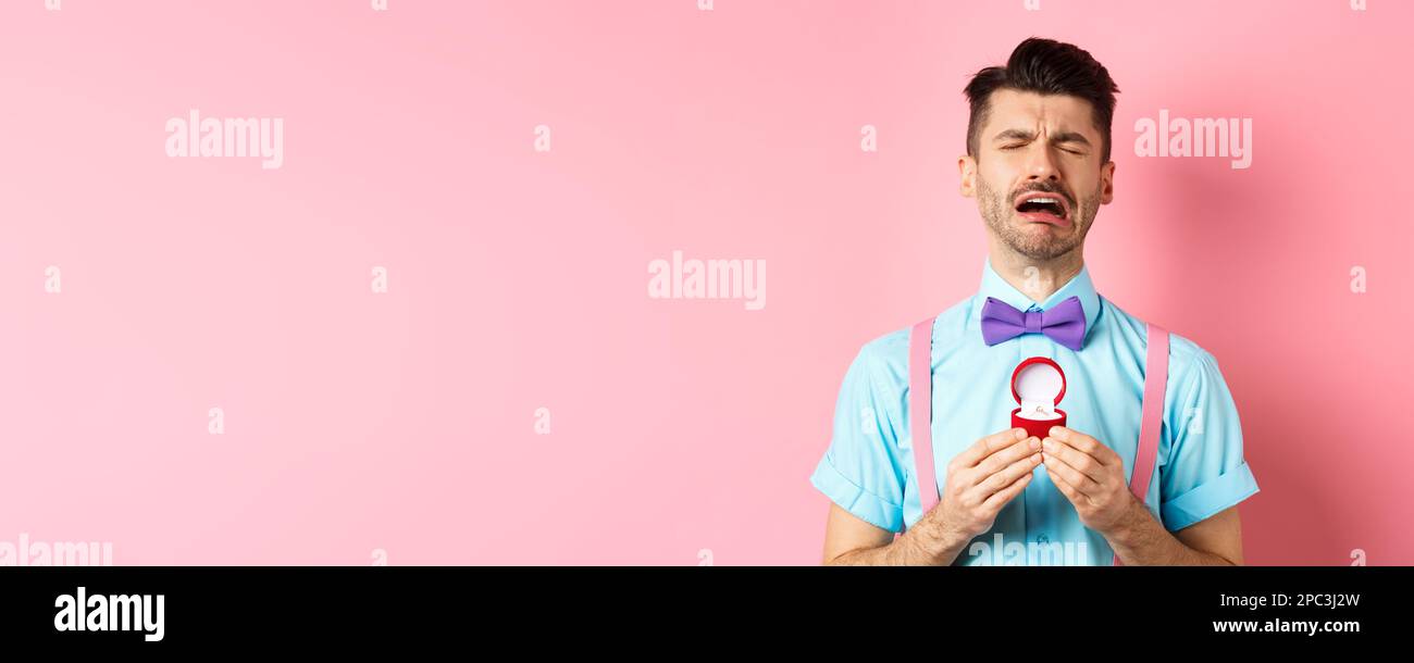 Valentines day. Heartbroken guy crying and holding engagement ring ...