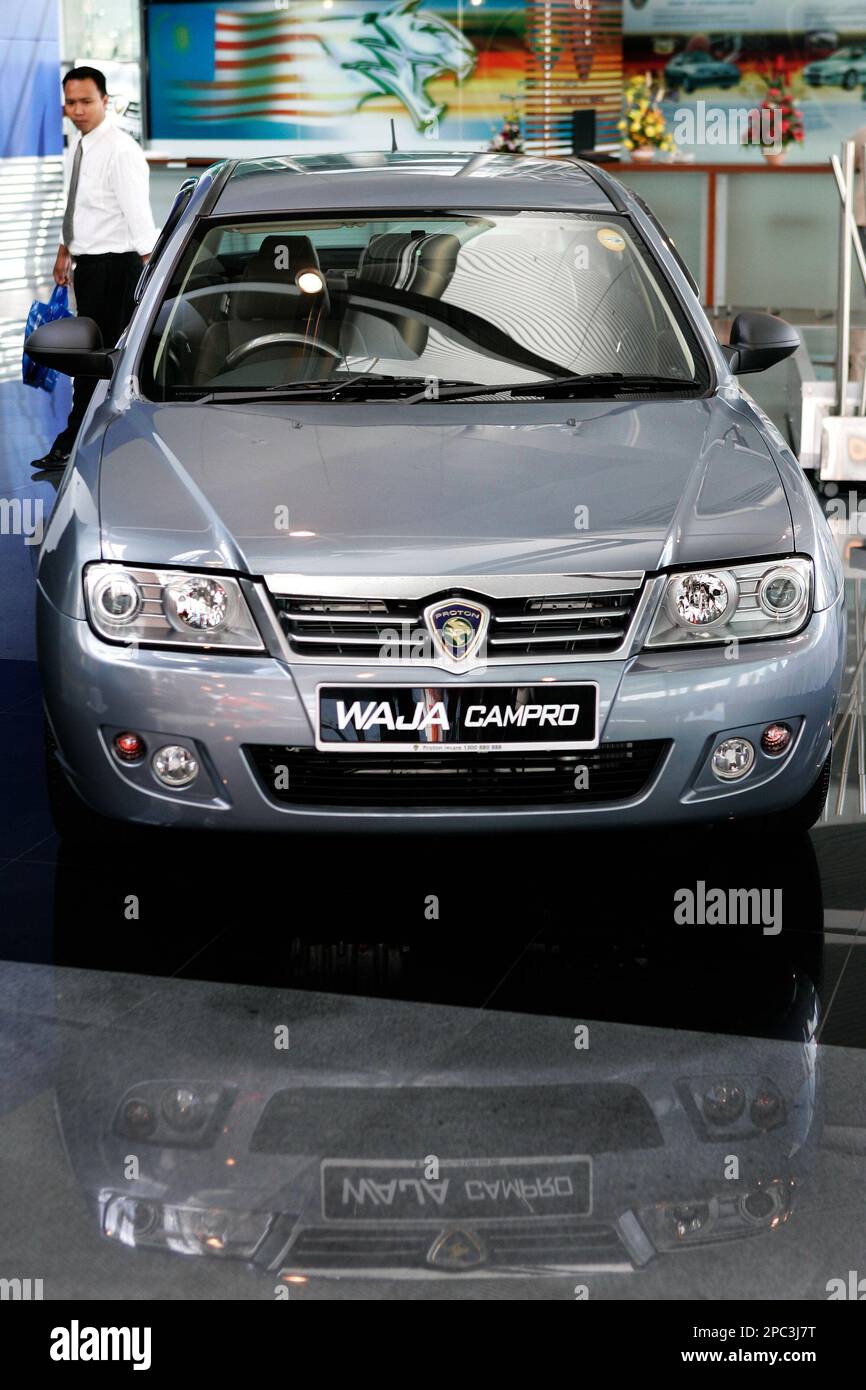 A visitor walks past a Proton Waja new face lift models on display at a ...