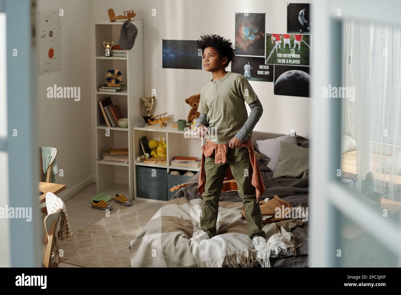 African American schoolboy practicing exercises of martial art while ...