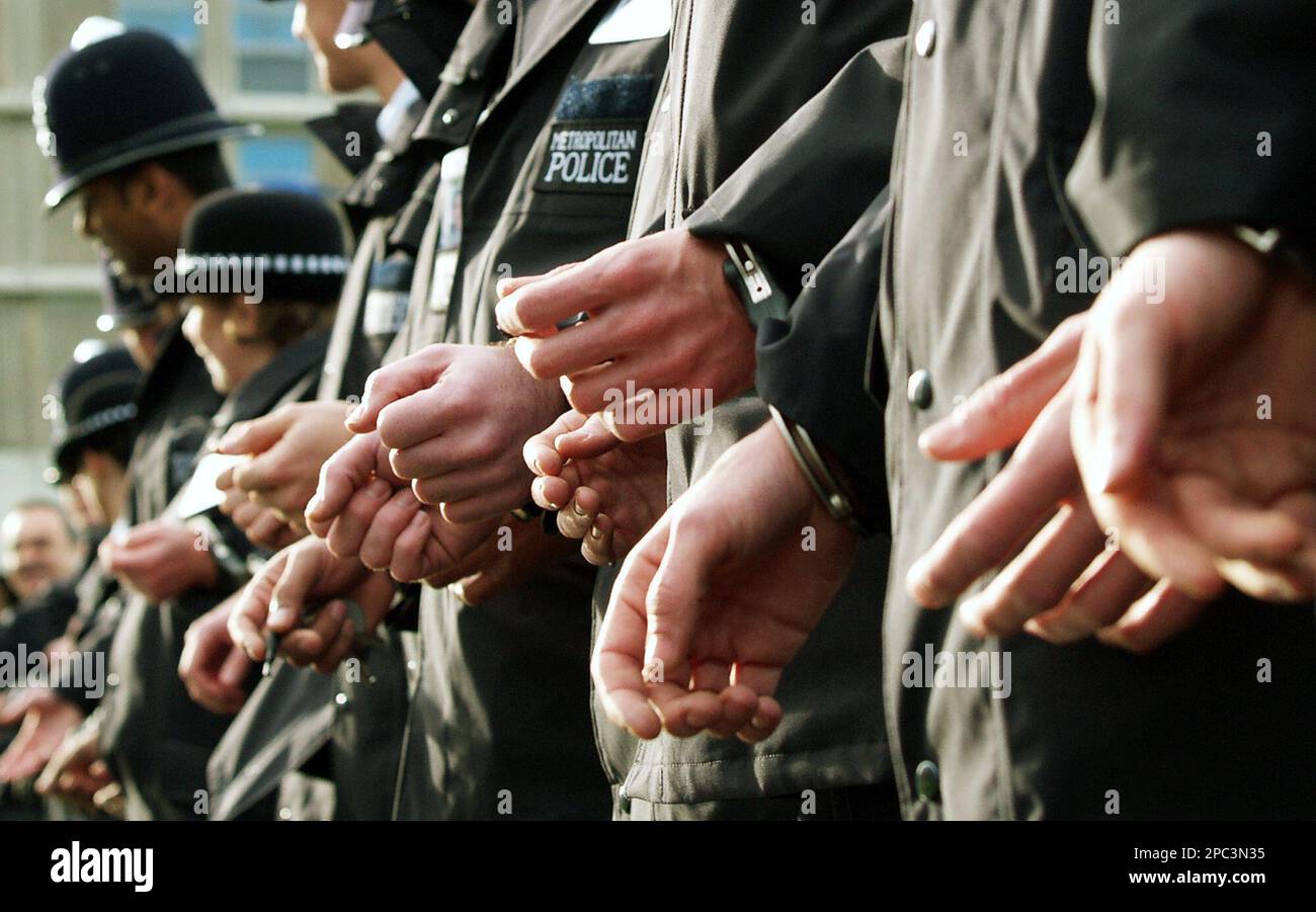 British police officers are handcuffed together on their way to setting ...