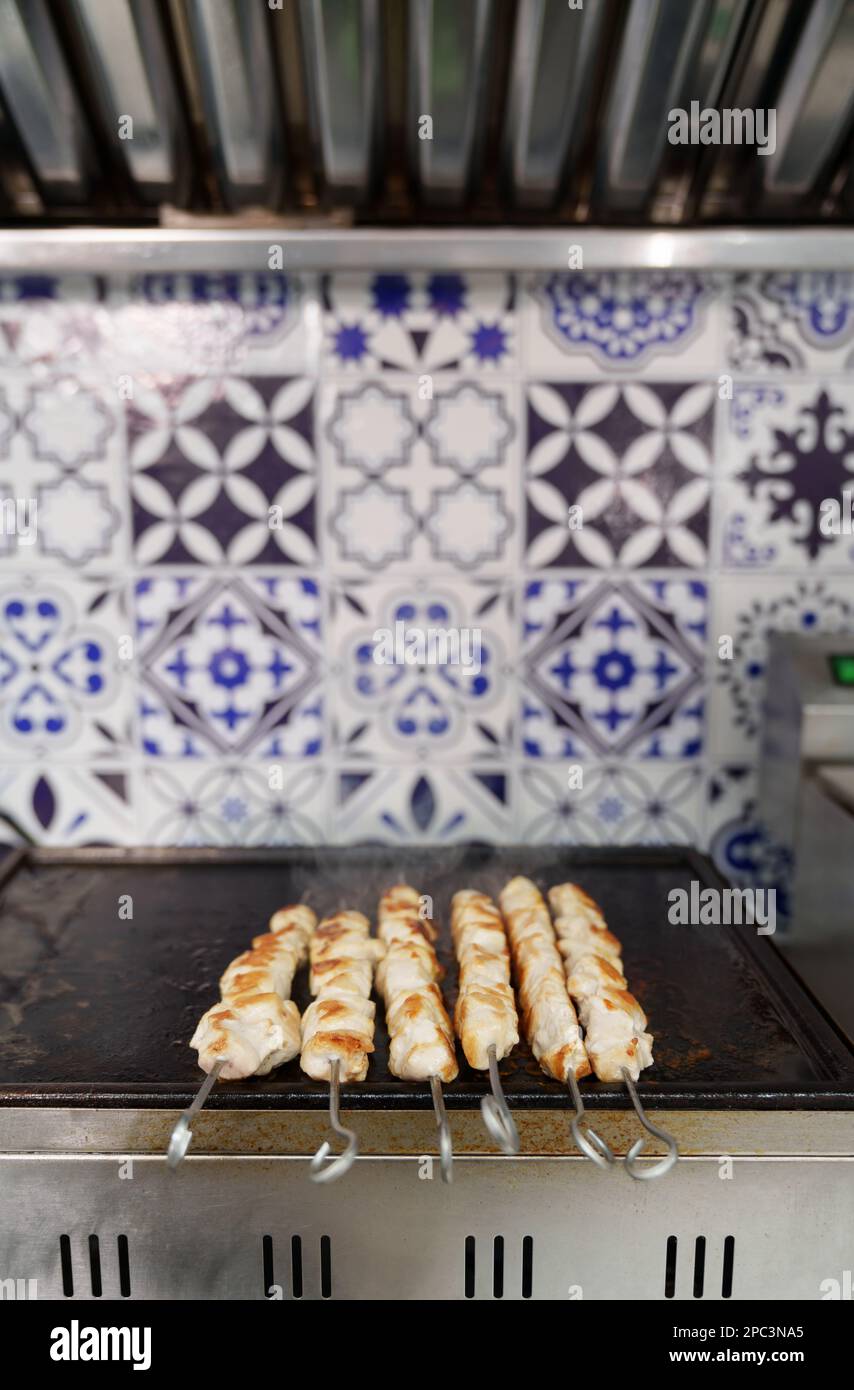 Chicken meat cooking on grill in commercial kitchen. White poultry ...