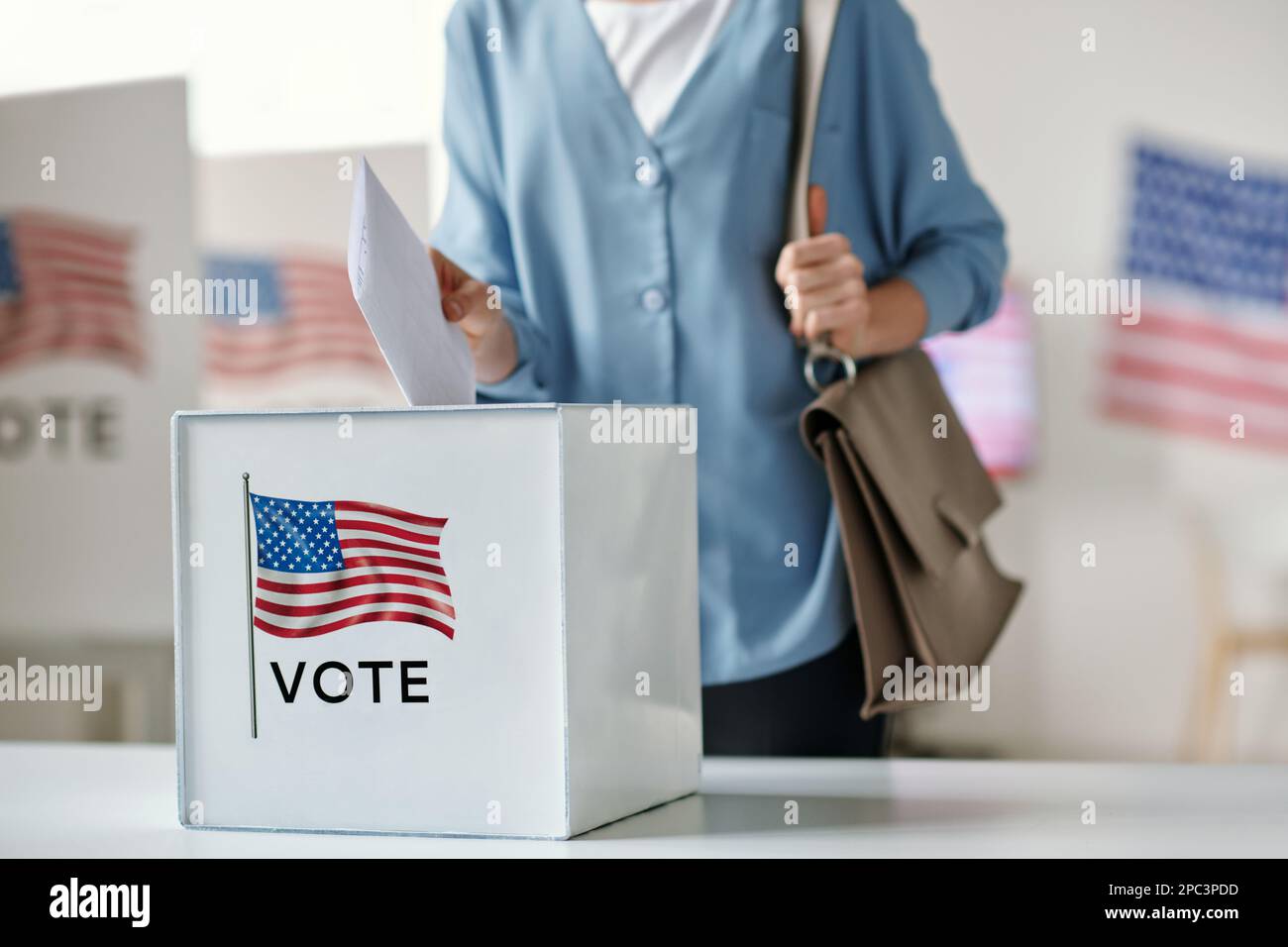 Young female citizen of United States of America putting paper into ...