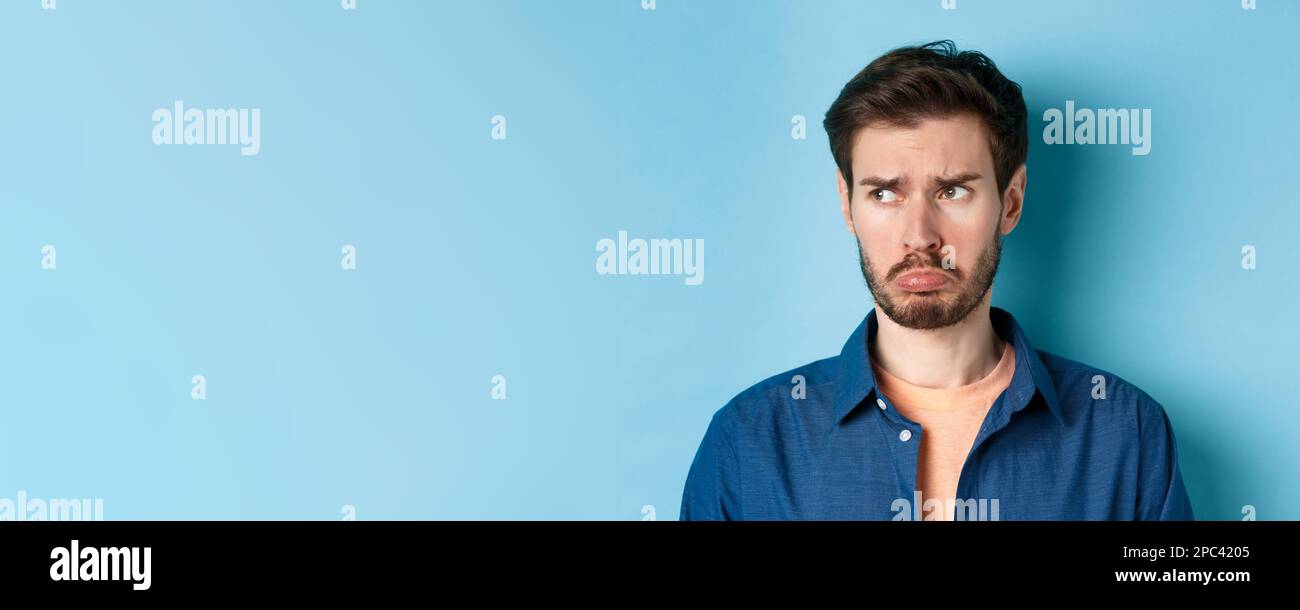 Miserable and disappointed guy acting childish, sulking and looking ...