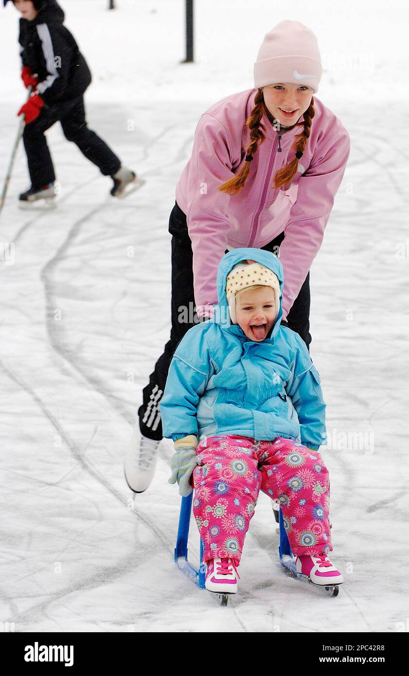 Taylor Piers, 17, pushes her little sister, Karley Piers, 3, on a chair ...