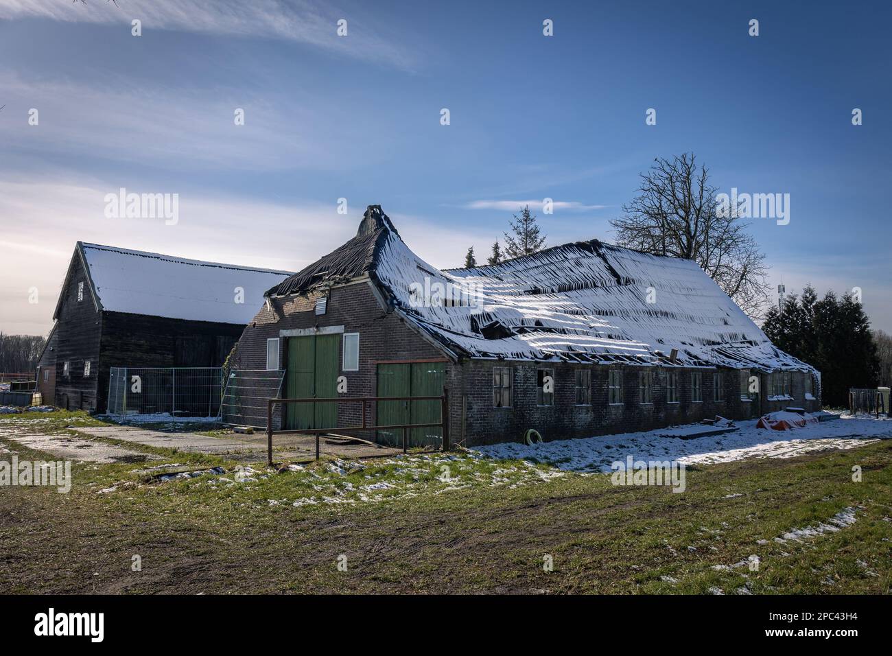 Old abandoned farmhouse in winter with a completely collapsed and snowy ...