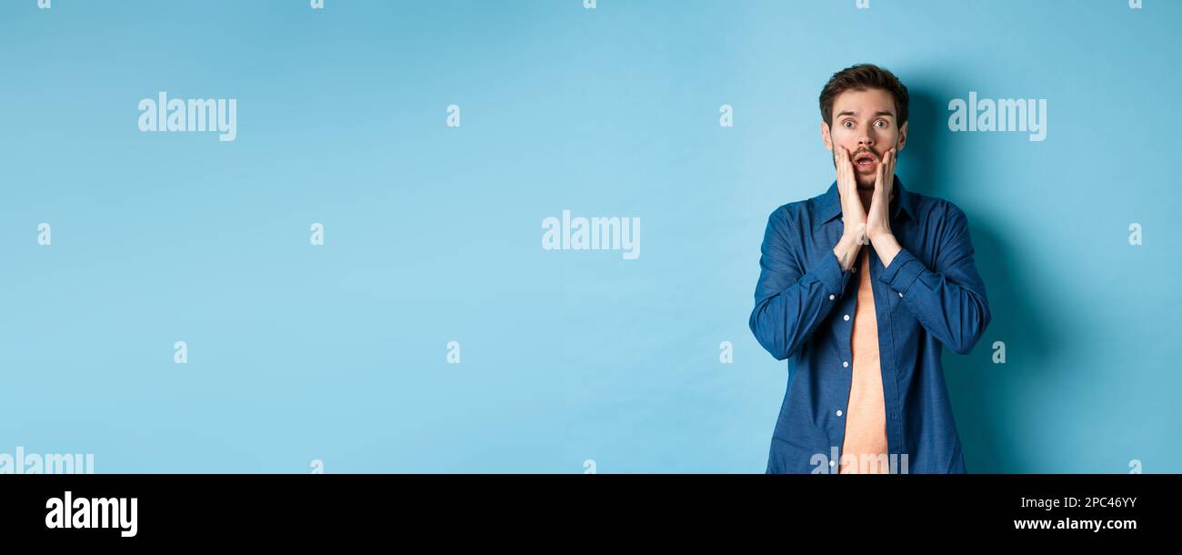 Portrait of guy gasping and dropping jaw with shocked face, staring at ...