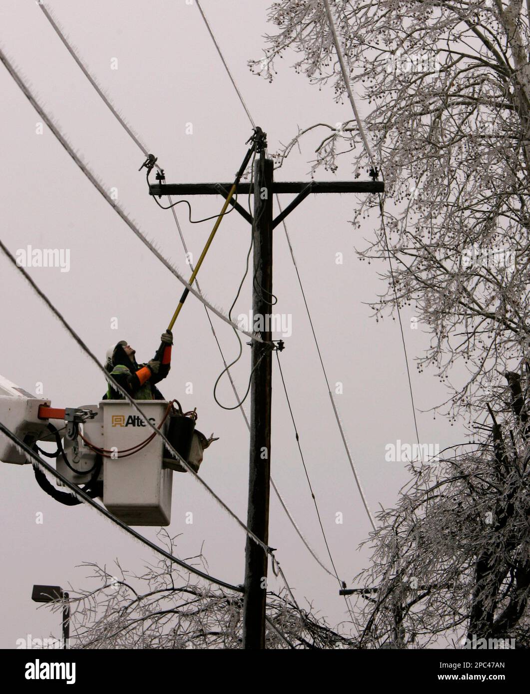 An Ameren utility worker works on an icy power line in an effort to ...
